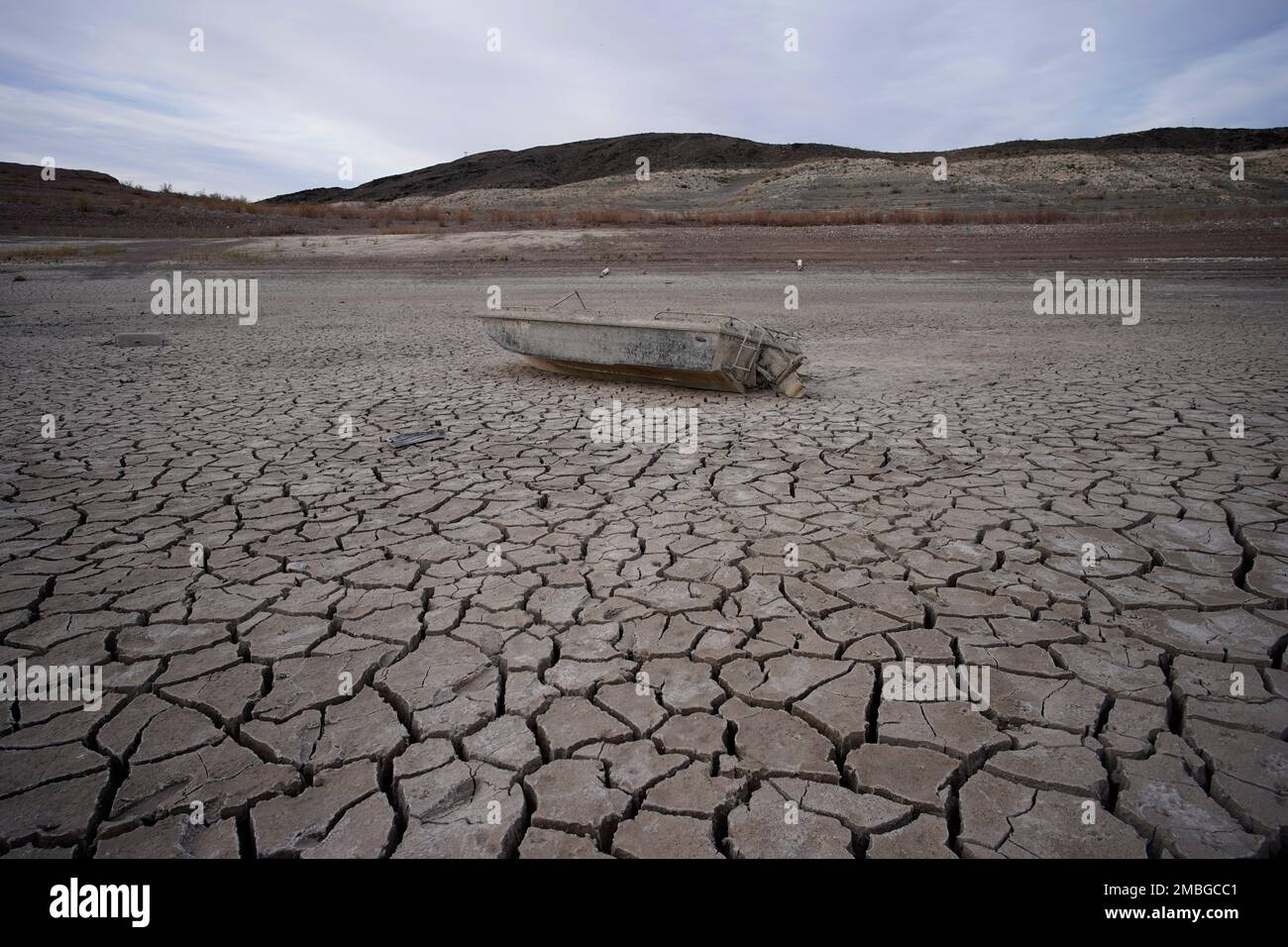 A formerly sunken boat sits on cracked earth hundreds of feet from the ...