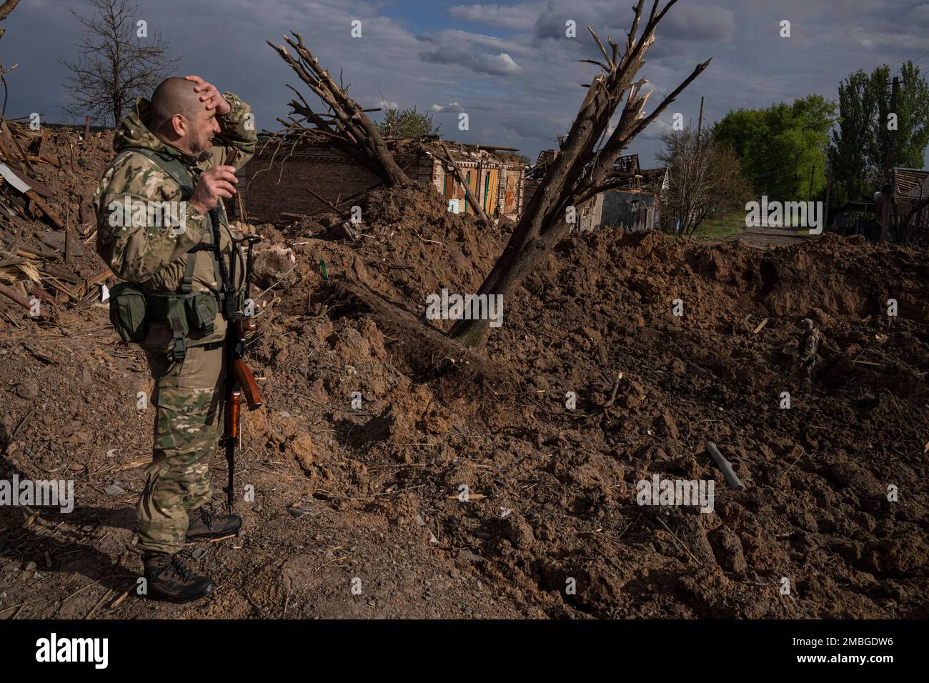 A Ukrainian serviceman inspects a site after an airstrike by Russian ...