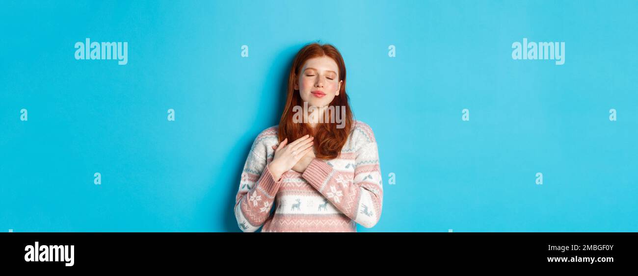 Image of dreamy redhead girl close eyes and holding hands on heart ...