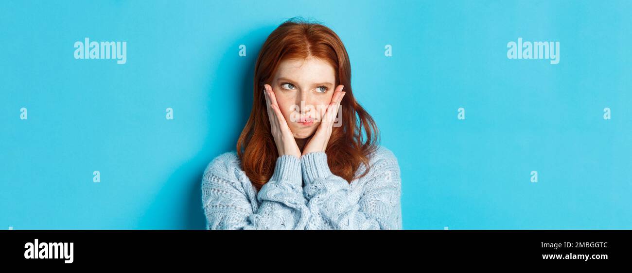 Close-up of troubled teenage girl with red hair staring left, pouting ...