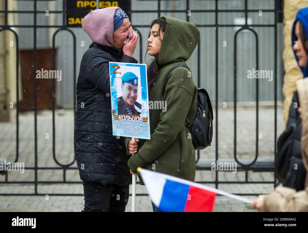 Women cry as they hold a portrait of Russian Army serviceman Alexander Koltsov, who was killed ...
