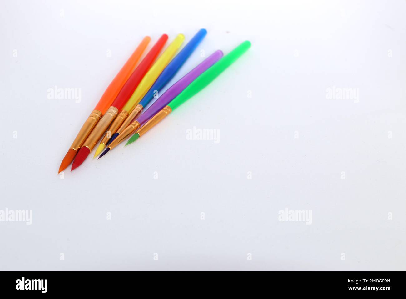A closeup shot of colorful painting brushes isolated on a white ...