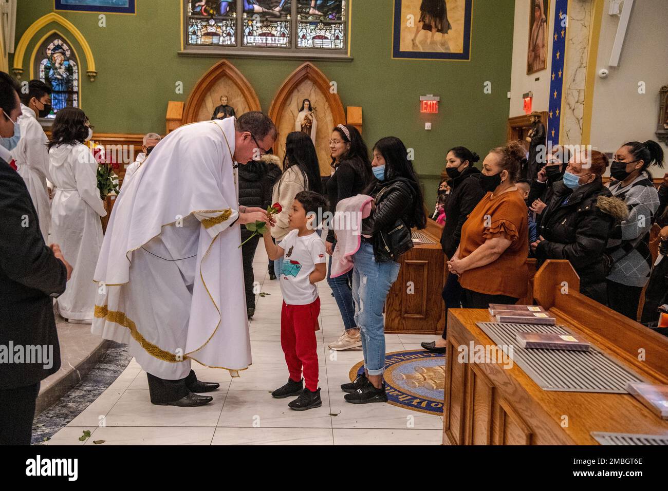Rev. Manuel Rodriguez hands out roses to families for mother's day at ...