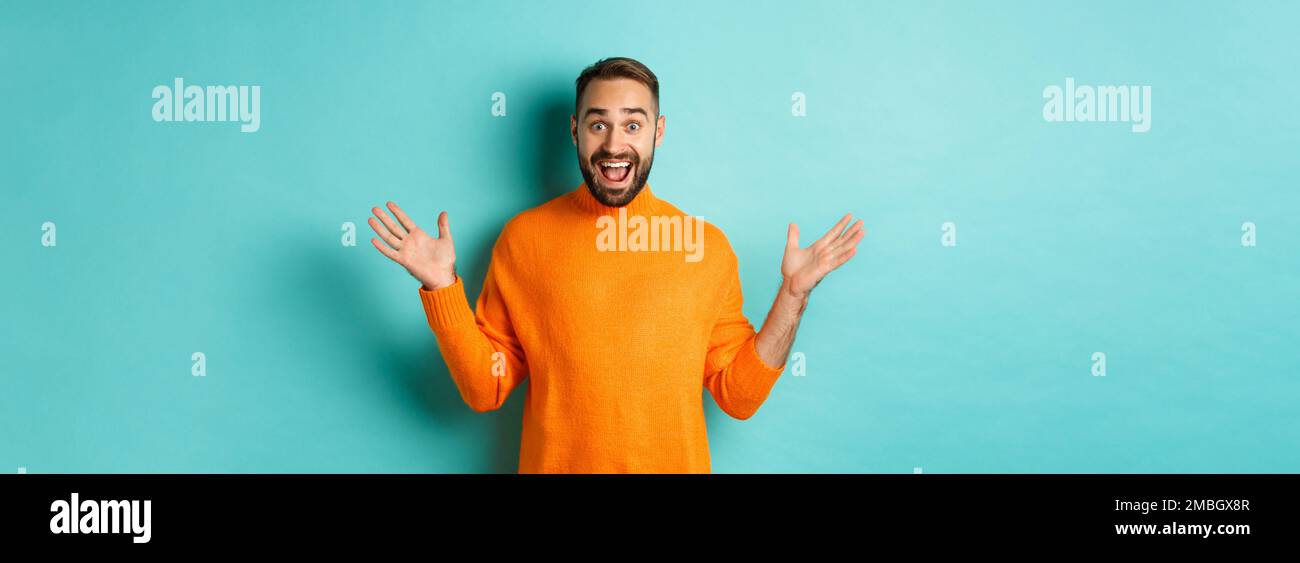 Excited man react to promo offer, spread hands sideways and rejoicing ...