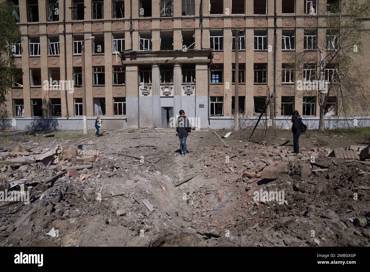 A woman looks on a crater of an explosion after Russian airstrike in ...