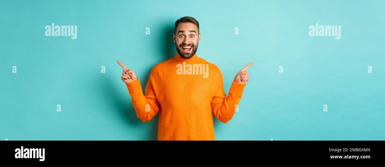 Shopping and advertisement concept. Excited man buyer pointing fingers ...