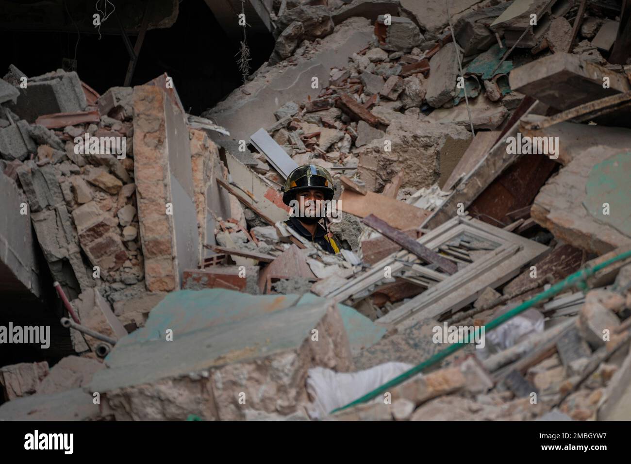 A rescuer looks out from the site of Friday's deadly explosion that ...
