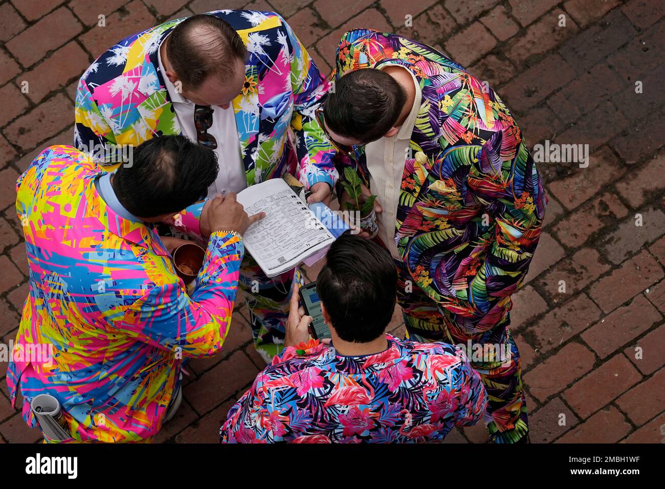 Fans look over a racing form before the 148th running of the Kentucky ...
