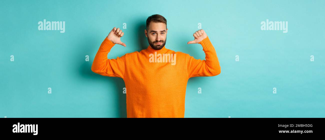 Confident attractive guy pointing at himself, show-off or brag ...