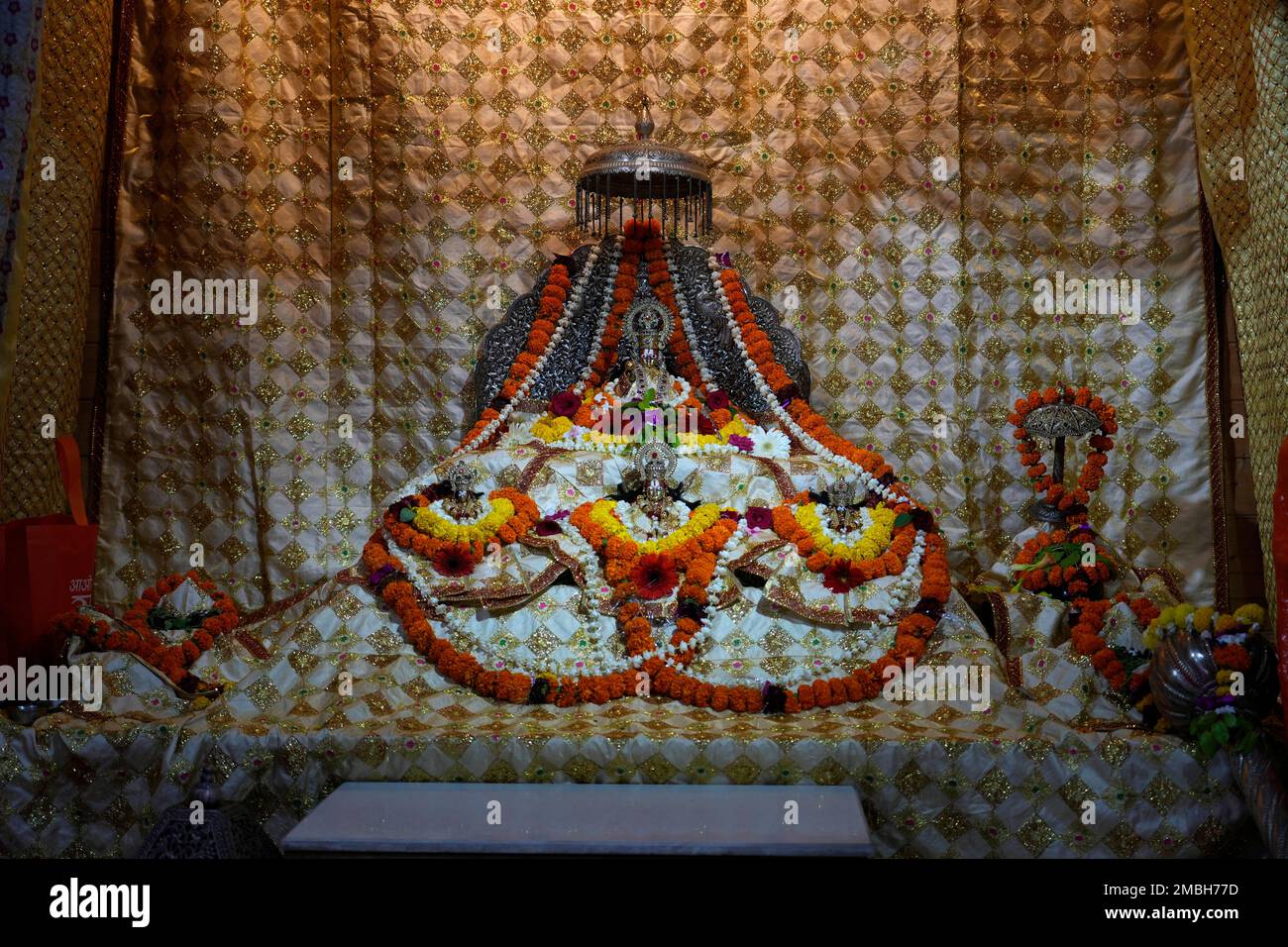 A deity stands at a makeshift temple near the under-construction site ...
