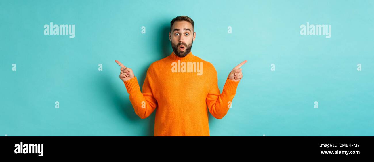 Shopping and advertisement concept. Excited man buyer pointing fingers ...