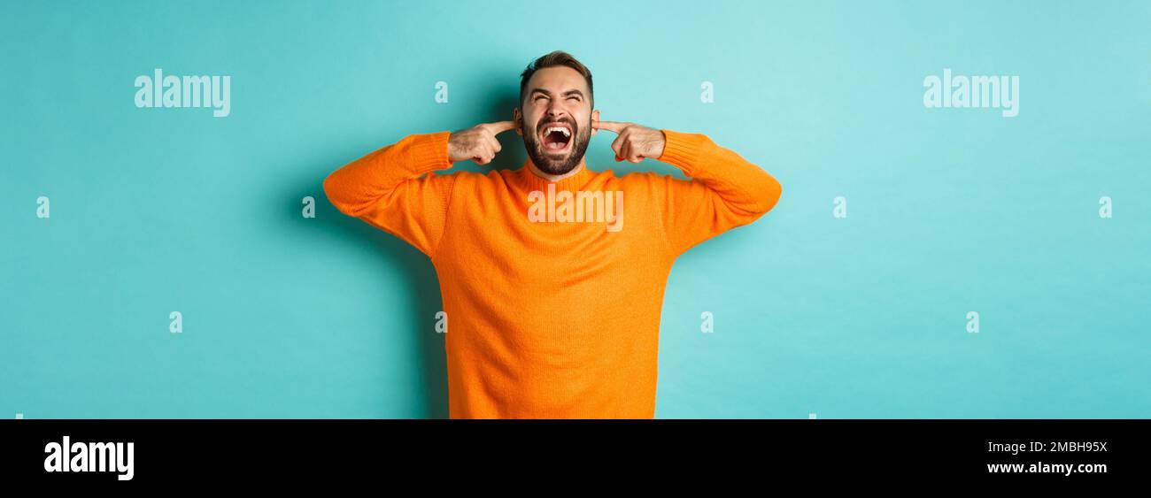 Frustrated and annoyed man shouting at neighbours upstairs, shut ears ...