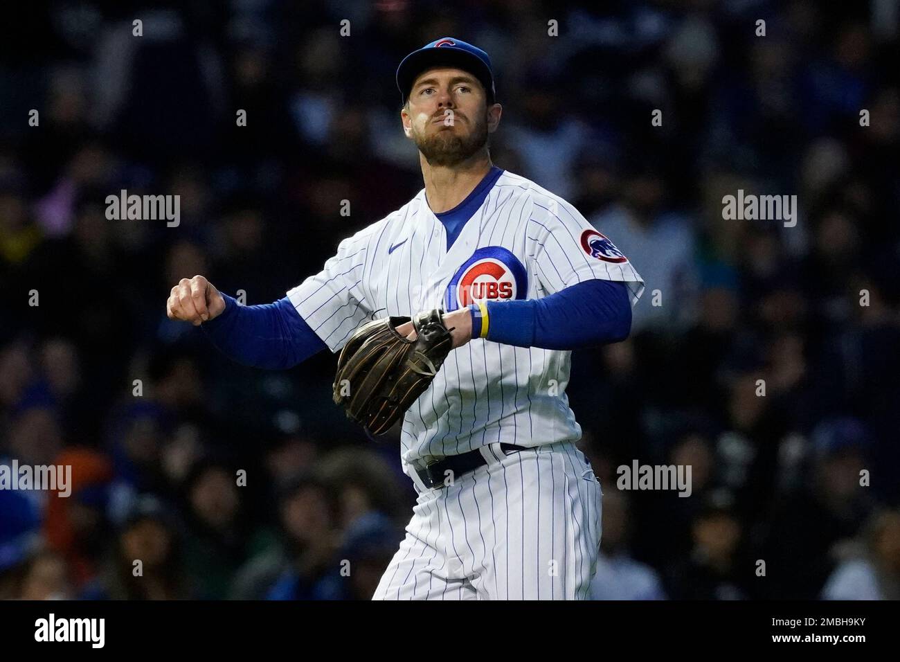 Chicago Cubs' Patrick Wisdom watches his throw to first in a baseball ...