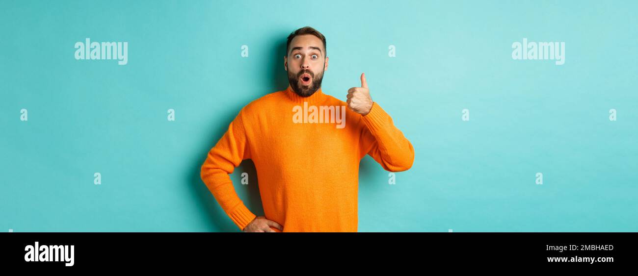 Well done. Handsome bearded man showing thumb up, praising good work ...