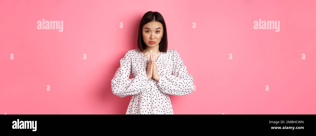 Cute asian girl asking for help, begging for favour and looking ...