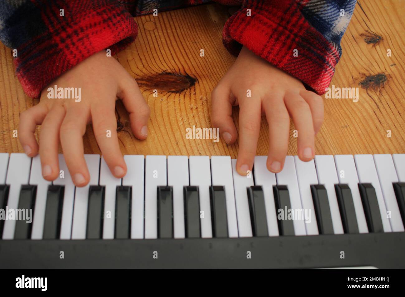 learning to play keyboards at home with a toy Stock Photo - Alamy