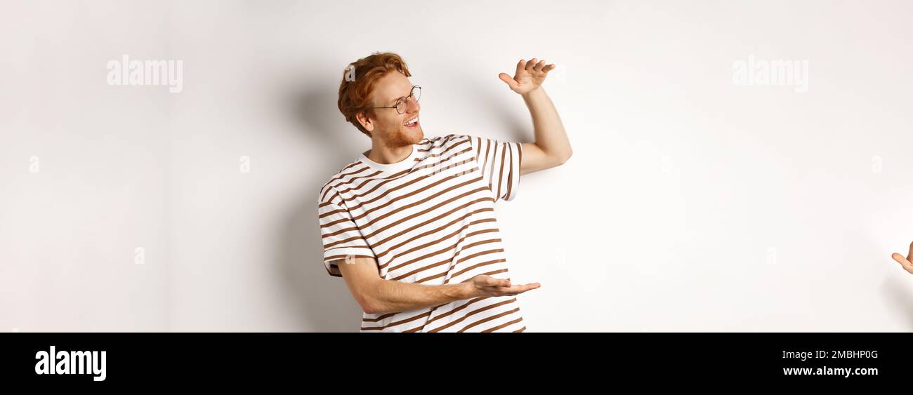 Happy and satisfied caucasian redhead man introduce something big ...