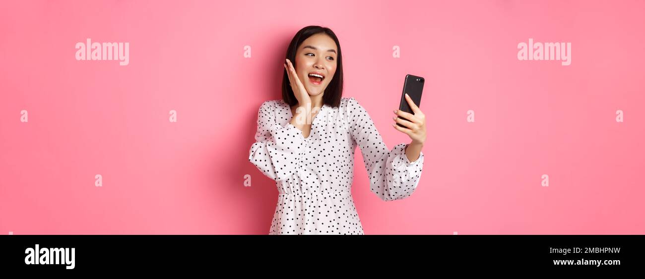 Beautiful asian girl using photo filters app and taking selfie on ...