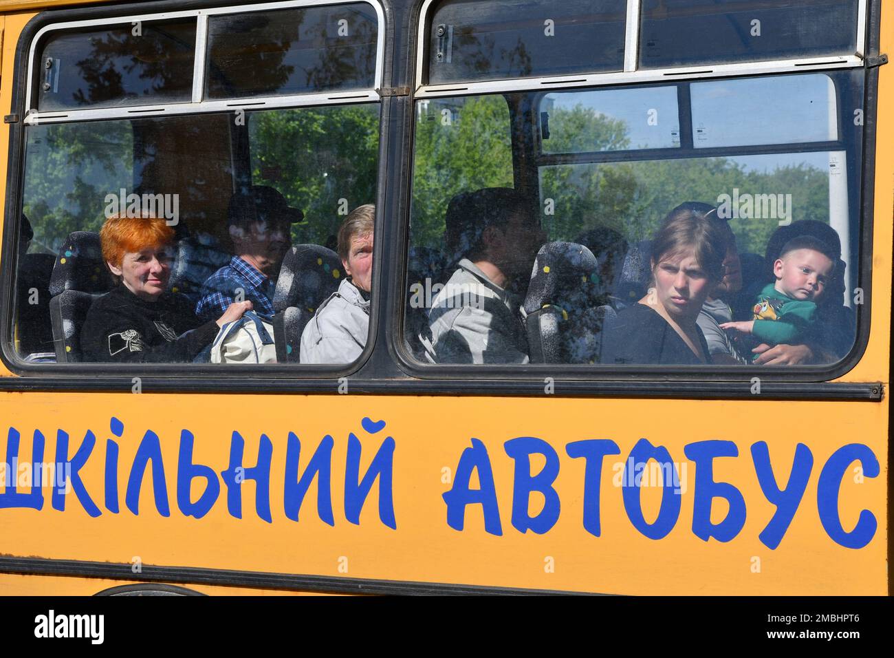 People with children sit in a bus during an evacuation of civilians in ...
