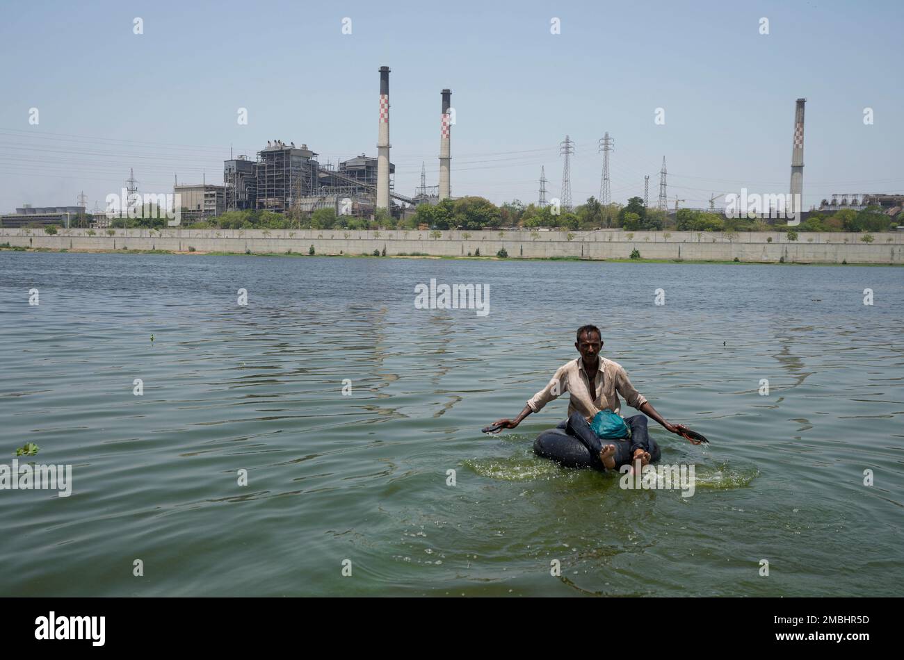 A thermal power station of Torrent Power Limited is seen behind as a ...