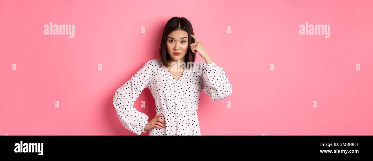 Image of attractive asian lady scolding person, pointing at head and ...