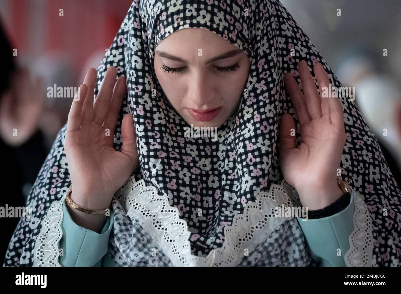 A woman prays during Eid al-Fitr prayers in Bucharest, Romania, Monday ...