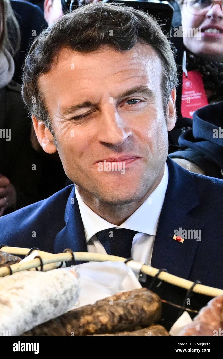 French President Emmanuel Macron blinks as he tours a market in the ...