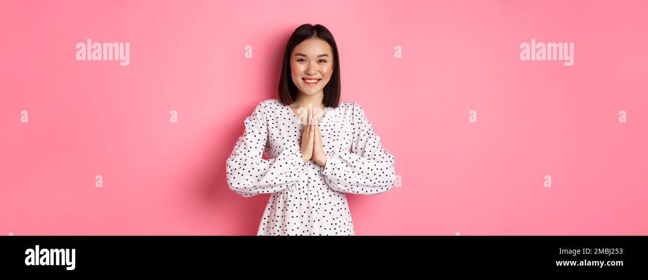 Beautiful asian woman thanking you, holding hands together in ...