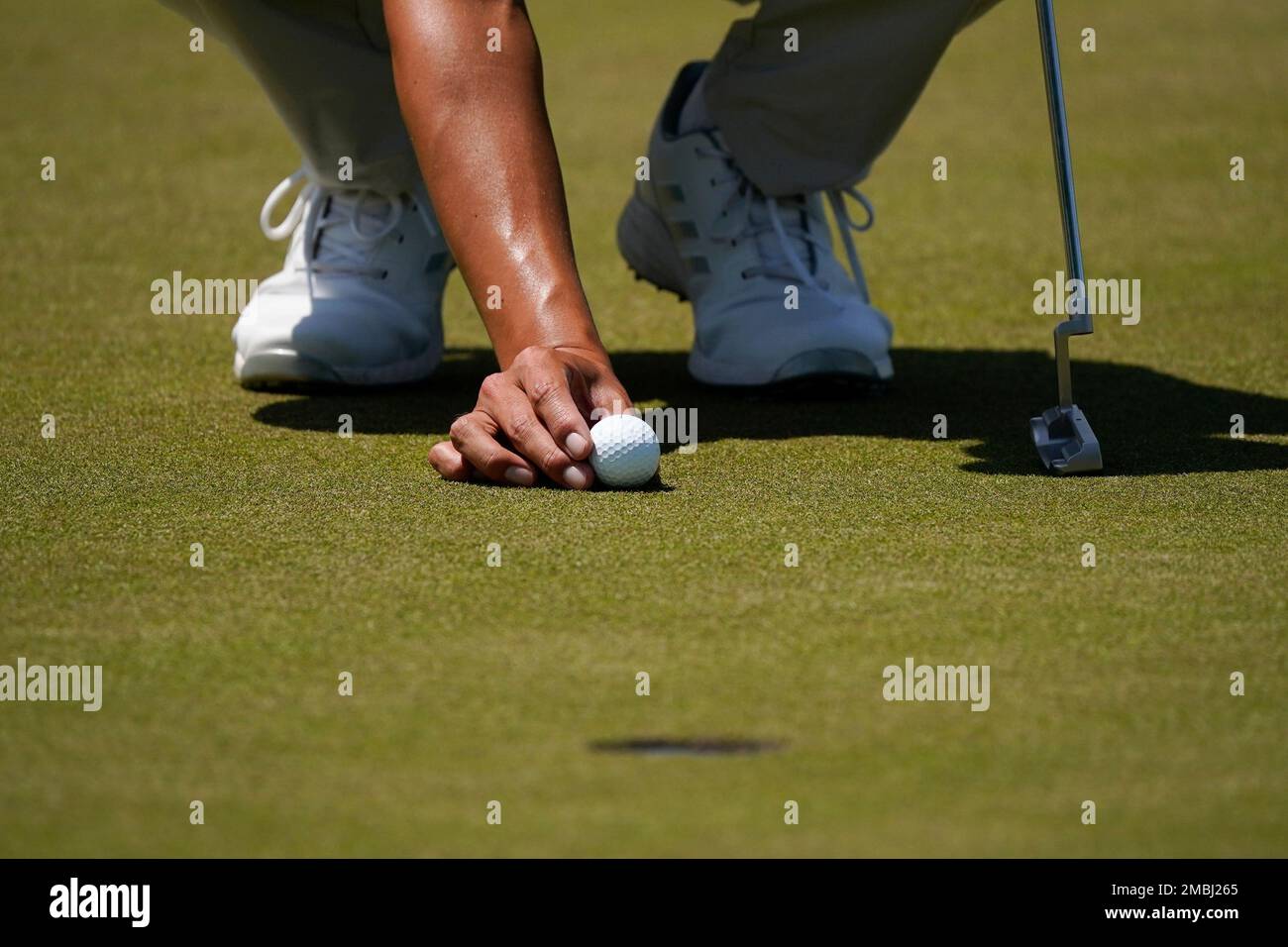 Brandon Wu, of the United States, places his ball on the 17th hole ...