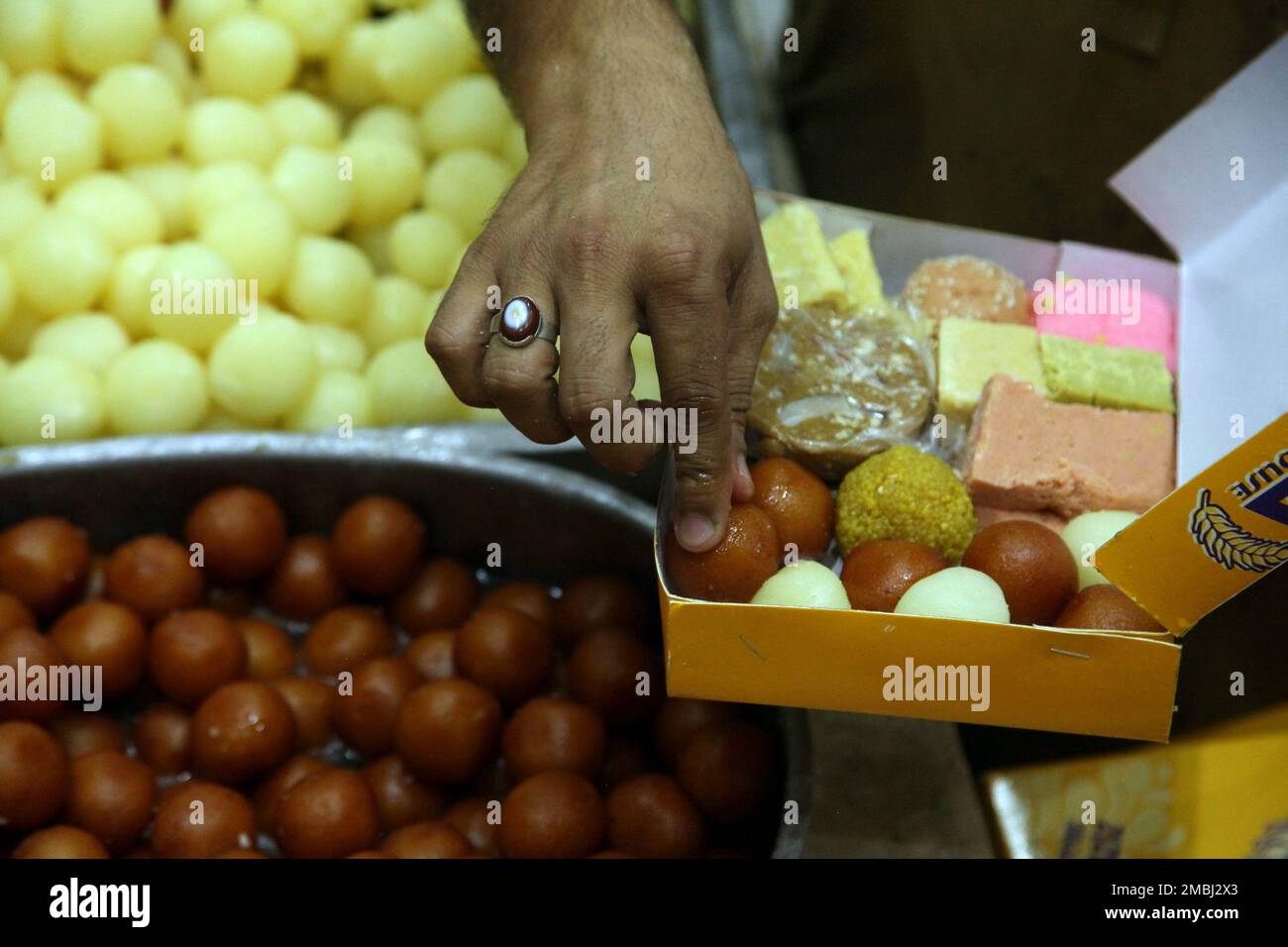 People buy sweets at a shop in preparation for the upcoming Eid al-Fitr ...