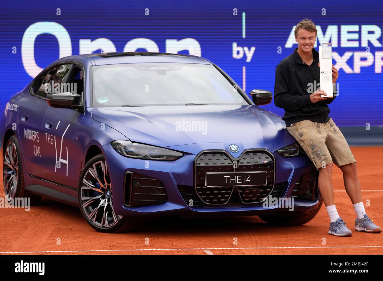 Holger Rune of Denmark poses with the trophy and the BMW i4 winner car ...