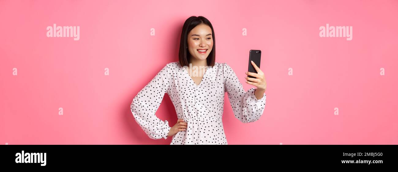 Beautiful asian girl using photo filters app and taking selfie on ...