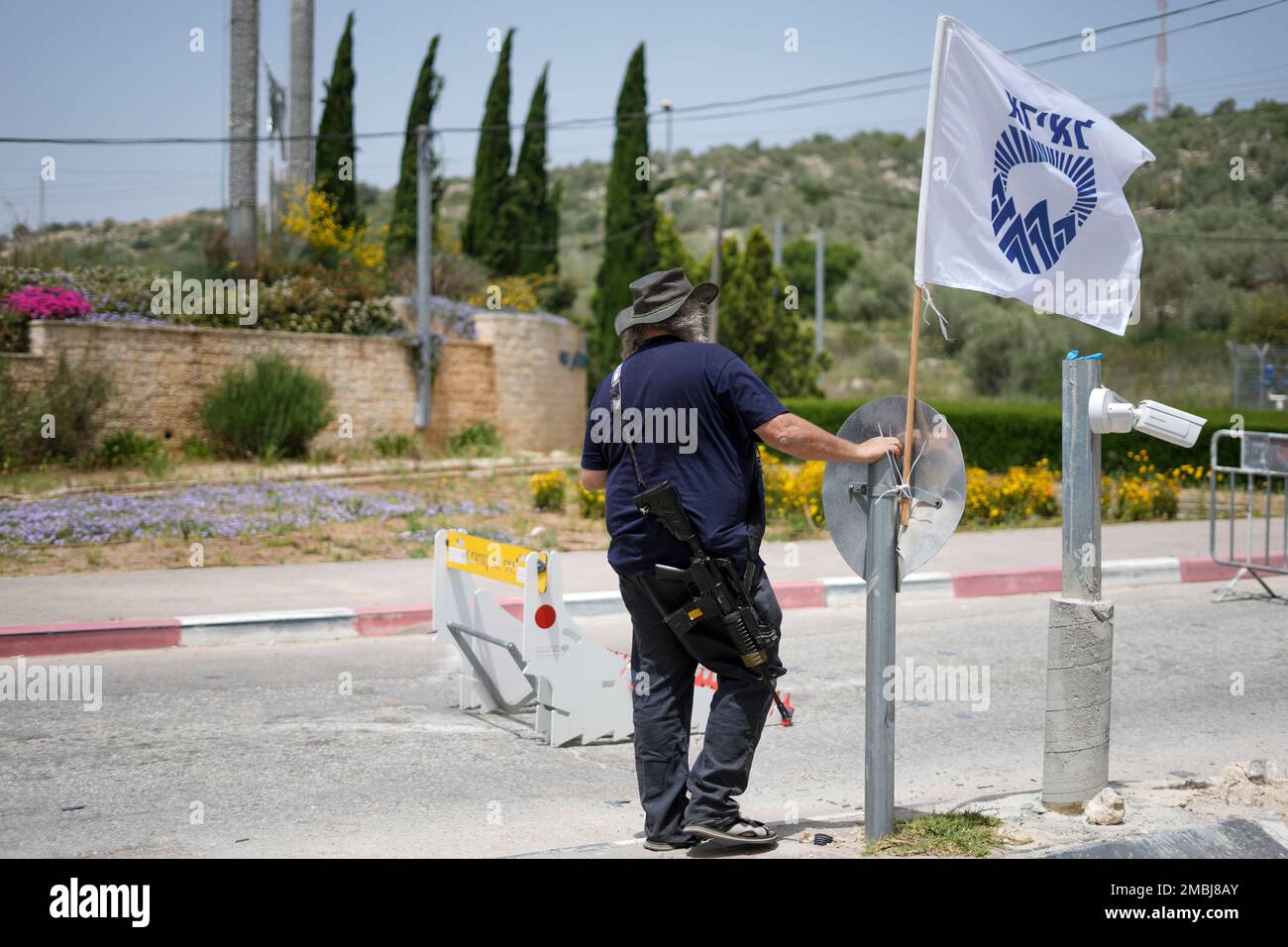 An Israeli security guard secures the entrance to the Jewish settlement ...