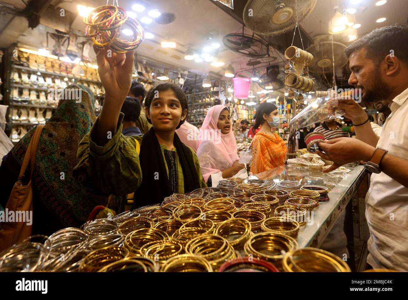 A young girl browses traditional bangles while she and others visit a ...