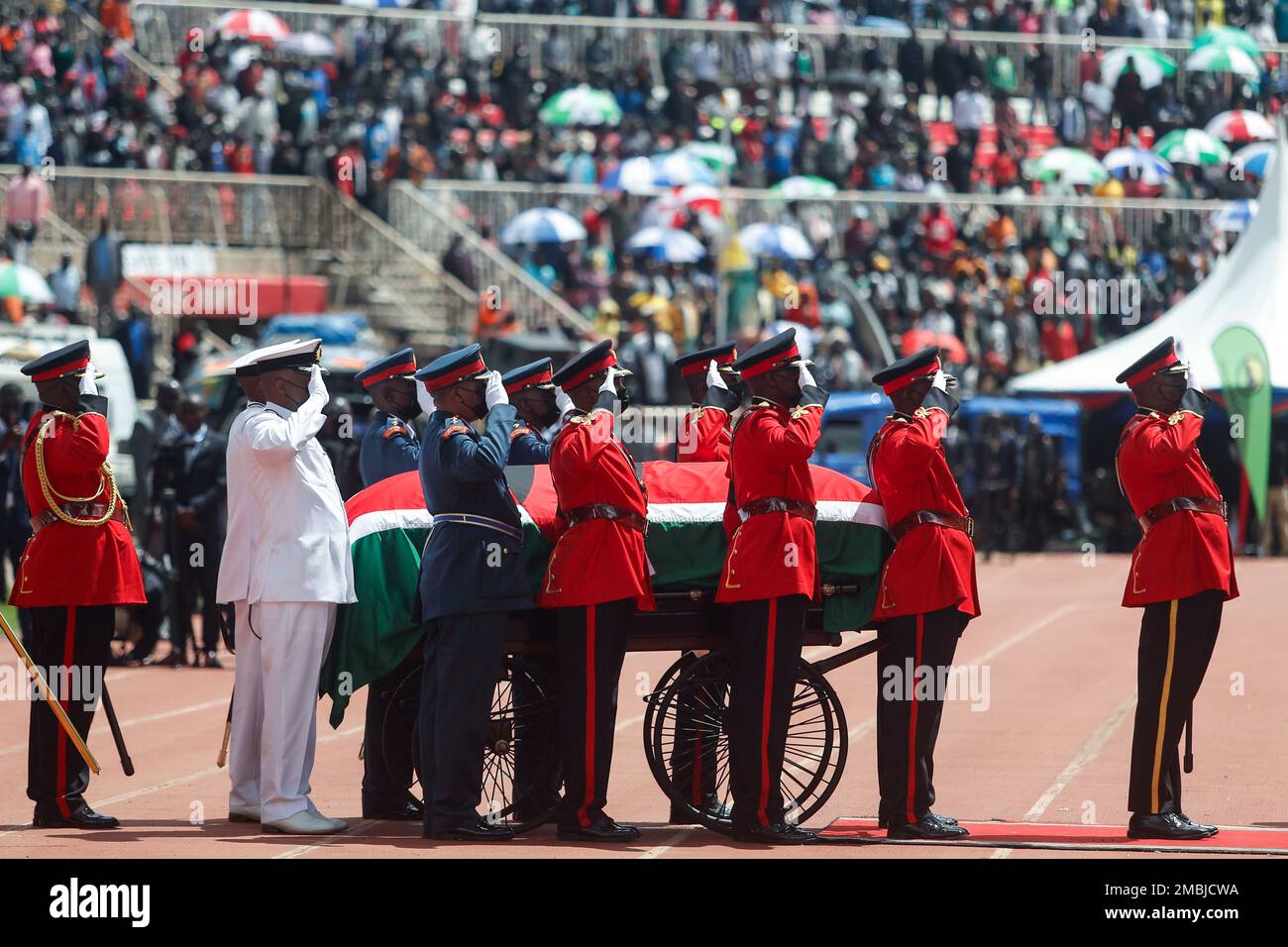 A military honour guard salutes next to the coffin of Kenya's former ...
