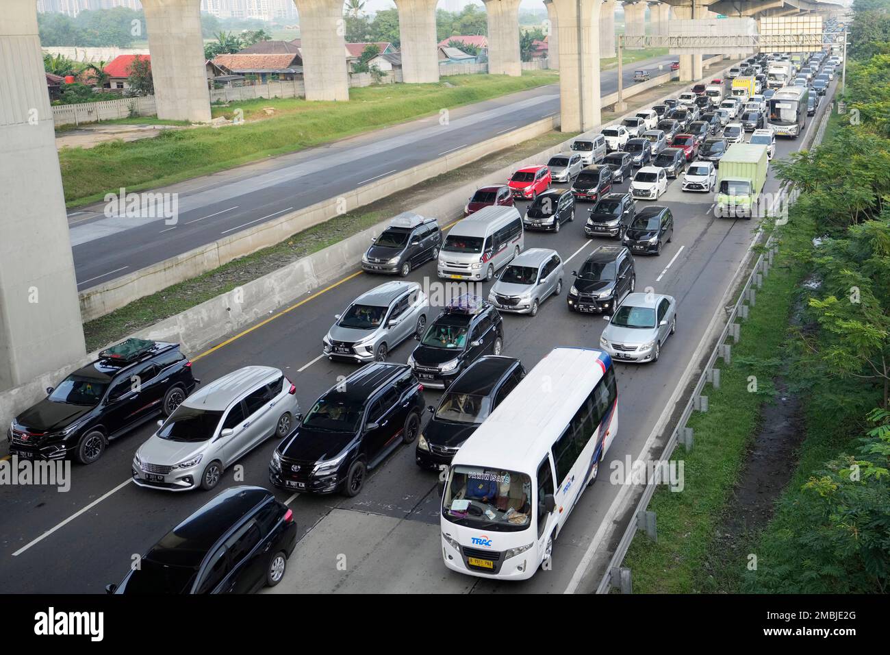 Vehicles are caught in a congestion as the flow of traffic increases at toll road in Cikarang ...