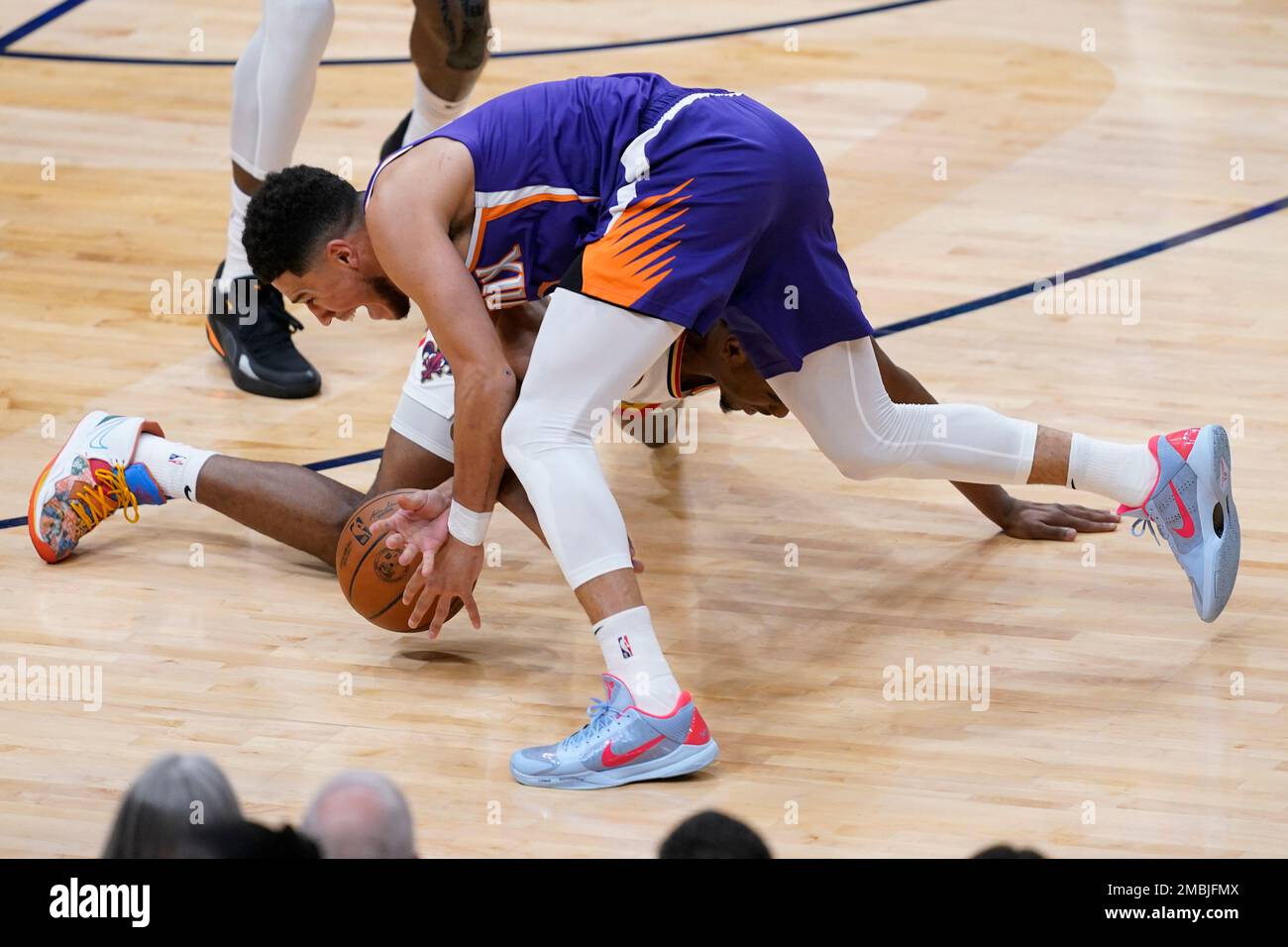 Phoenix Suns guard Devin Booker battles for a loose ball in the first ...