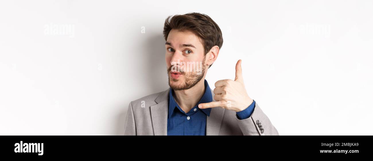 Handsome macho guy in suit showing phone sign near ear, flirting and ...