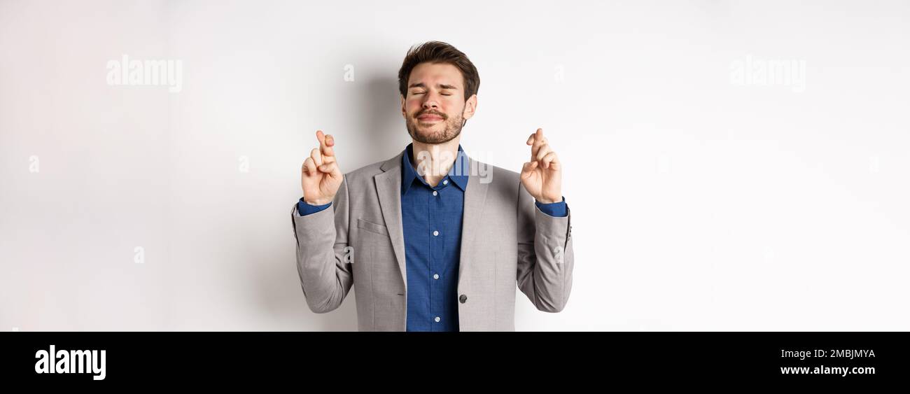 Nervous businessman in suit begging god, holding fingers crossed with ...