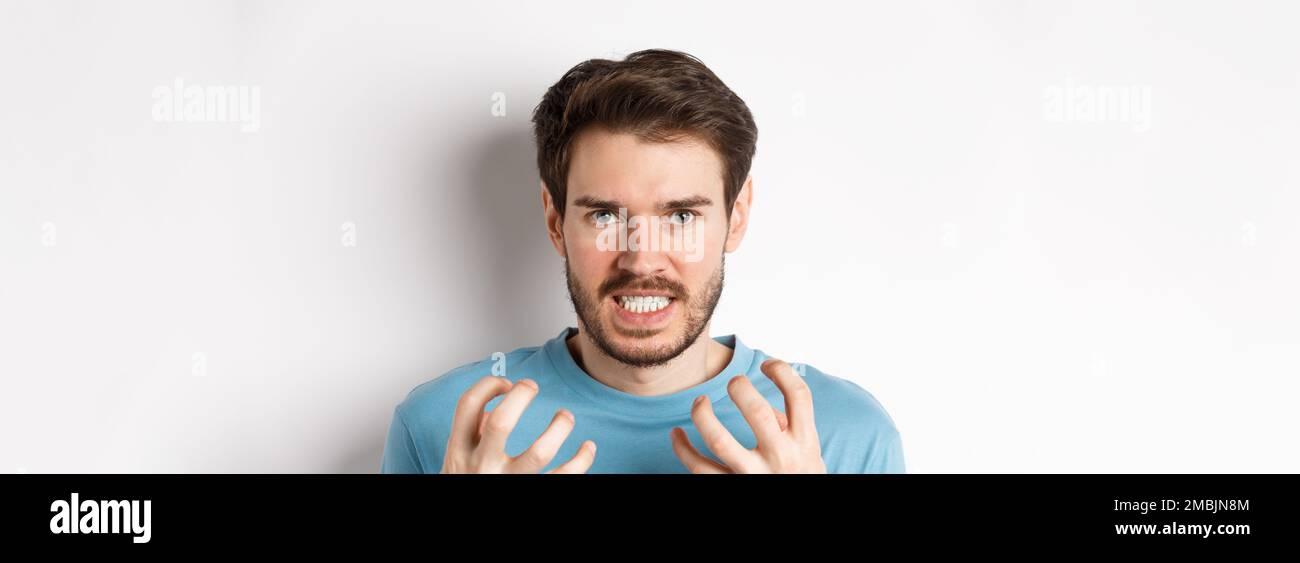 Close up of angry young man with beard, shaking hands mad, squeeze ...