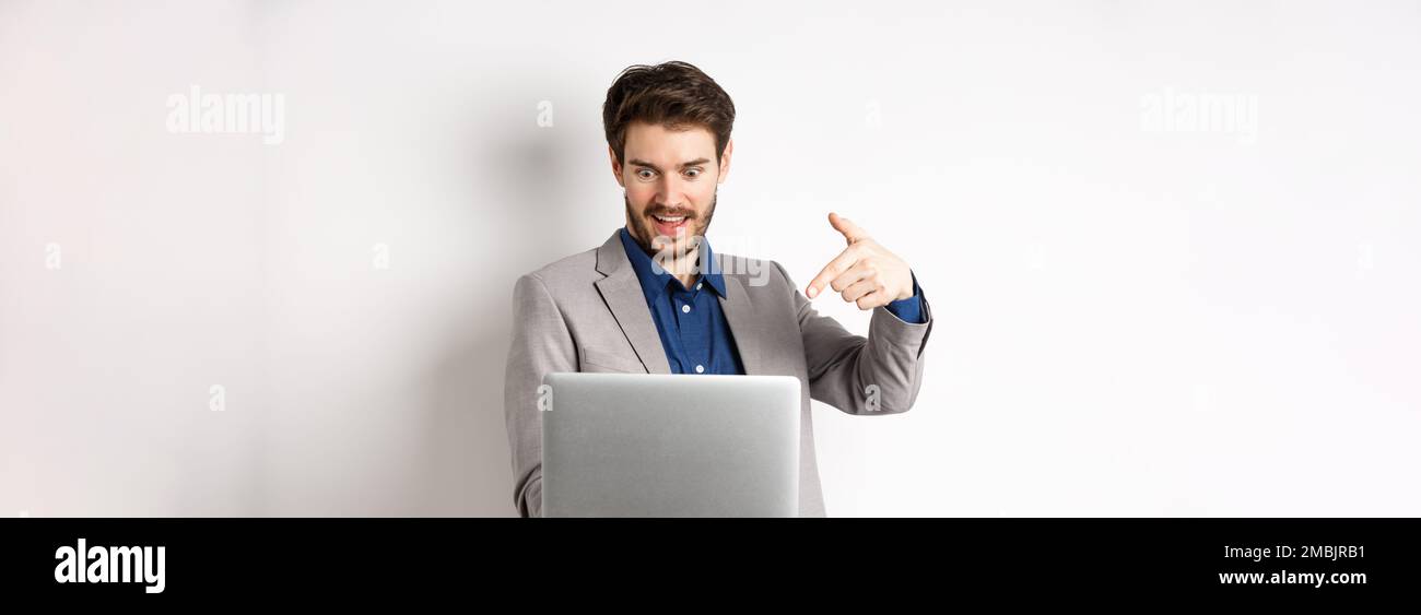 Excited male ceo manager looking and pointing at laptop with amazed ...