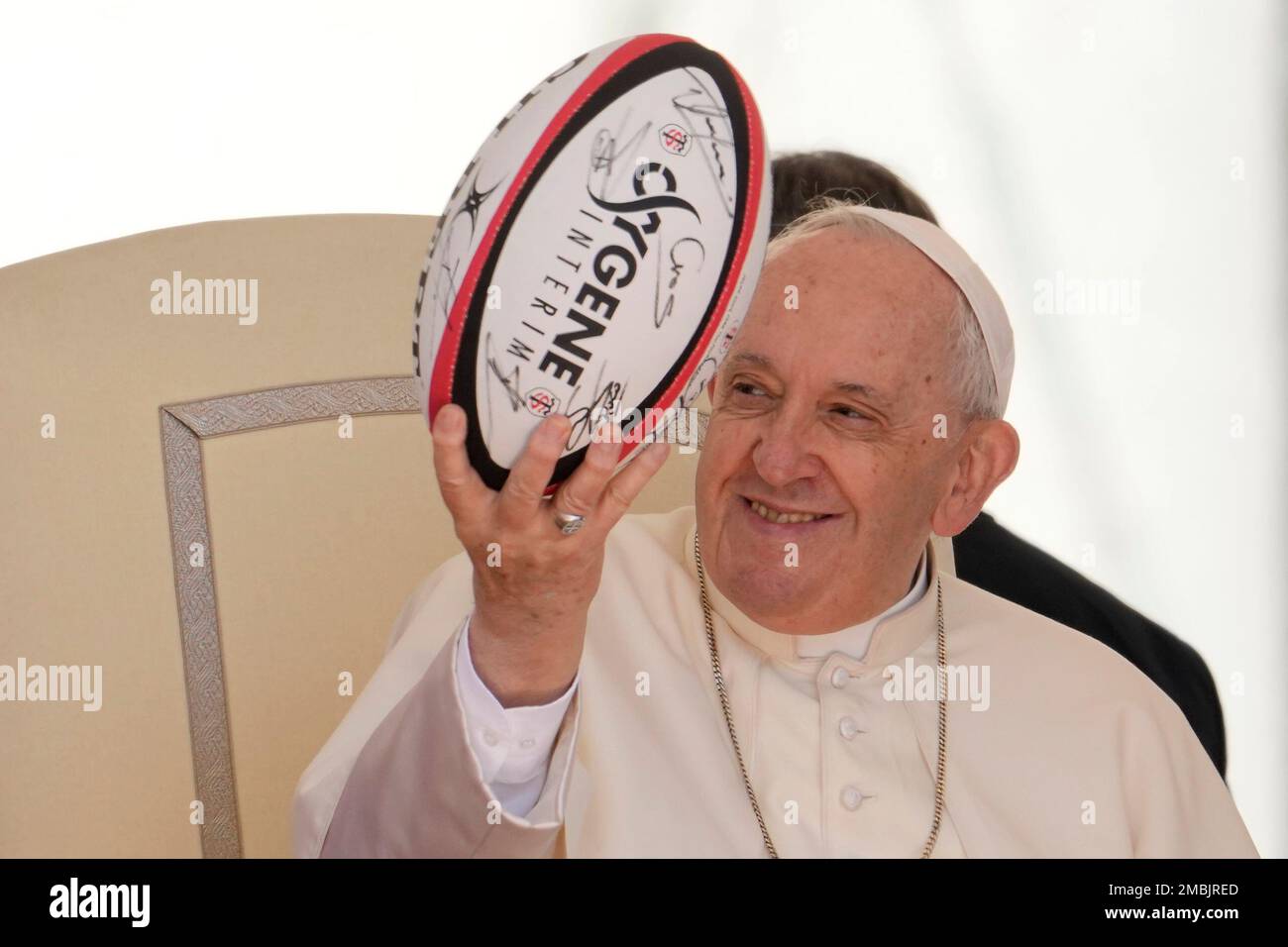 Pope Francis shows a rugby ball presented by bishop Emmanuel Gobillard ...