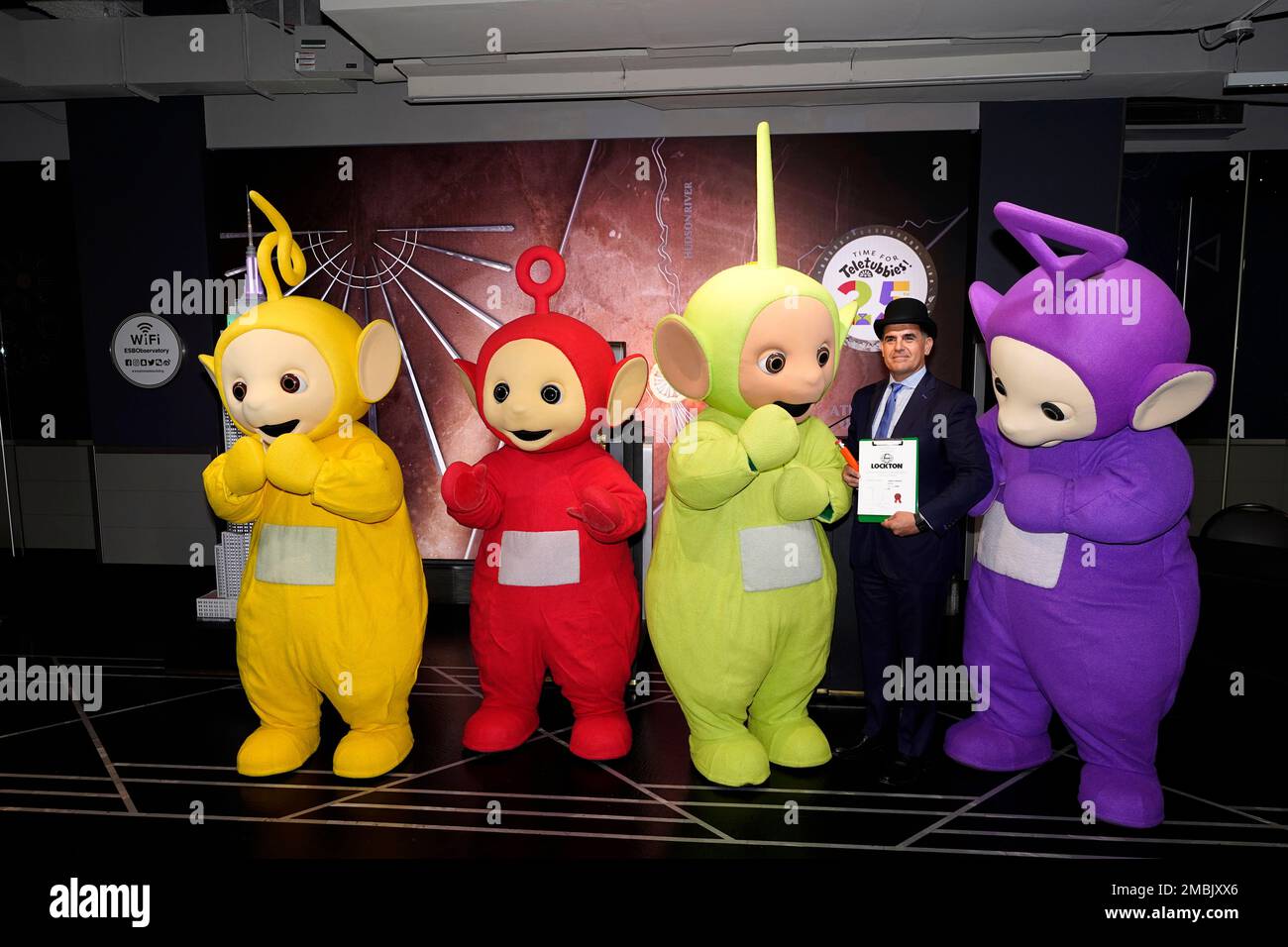 The Teletubbies pose with a representative from Lloyd's of London ...