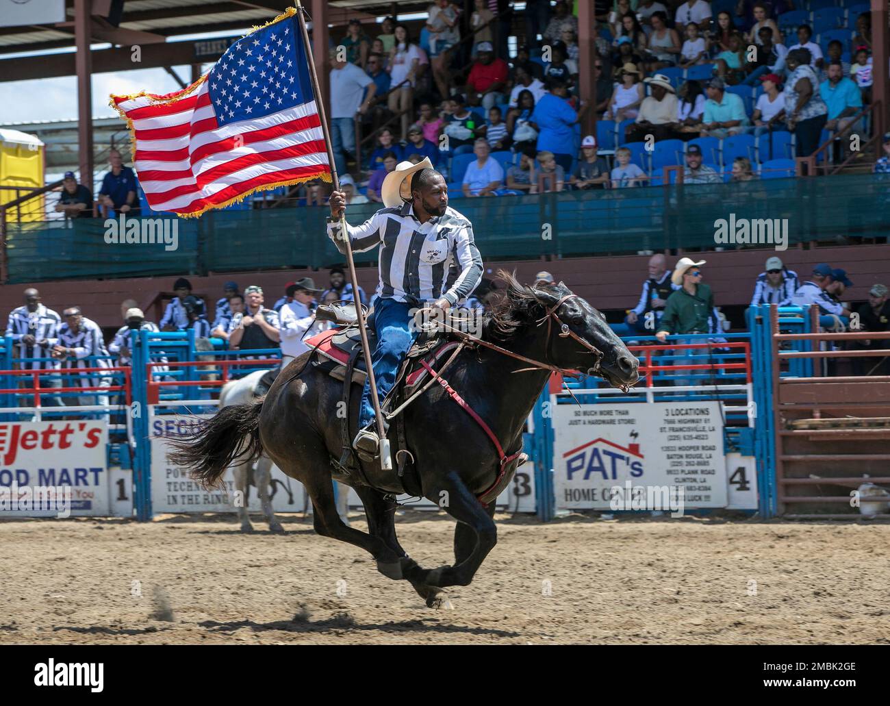 A rider charges with the flag during the grand entry as inmates compete ...