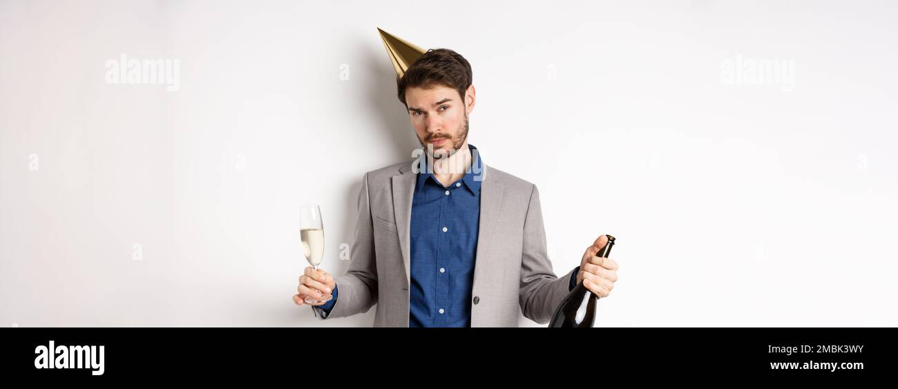 Party guy standing in birthday hat and celebrating, holding champagne ...