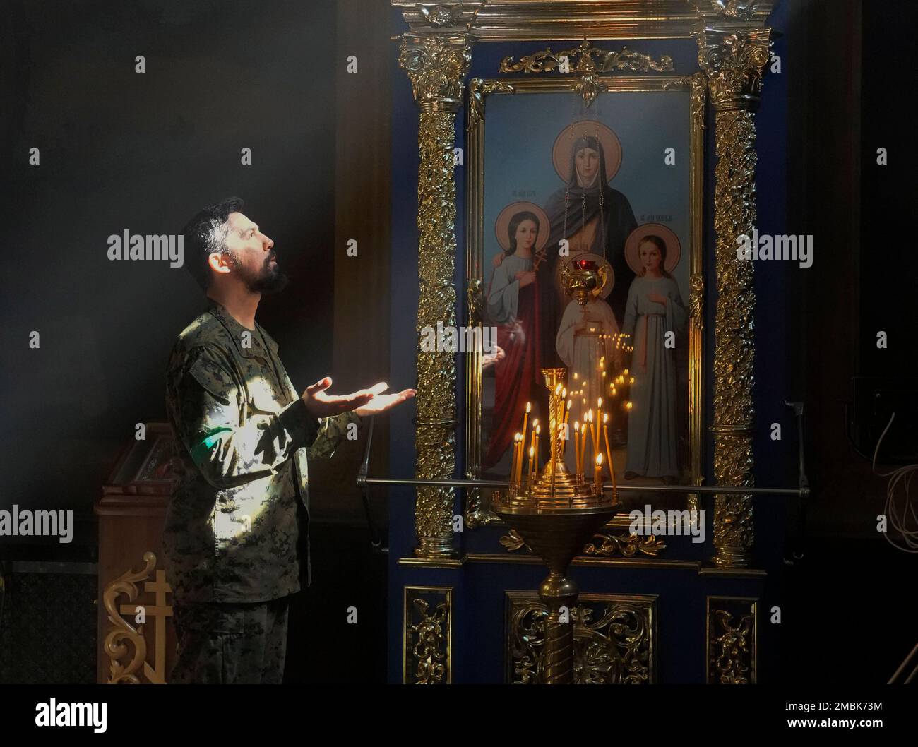 A Ukrainian soldier prays in St. Michael Cathedral during Orthodox ...