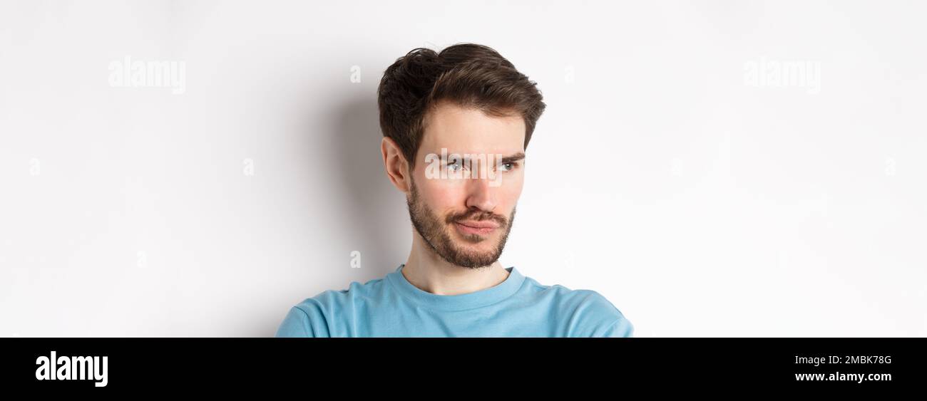 Close-up of disappointed bearded man, sulking and looking left with ...