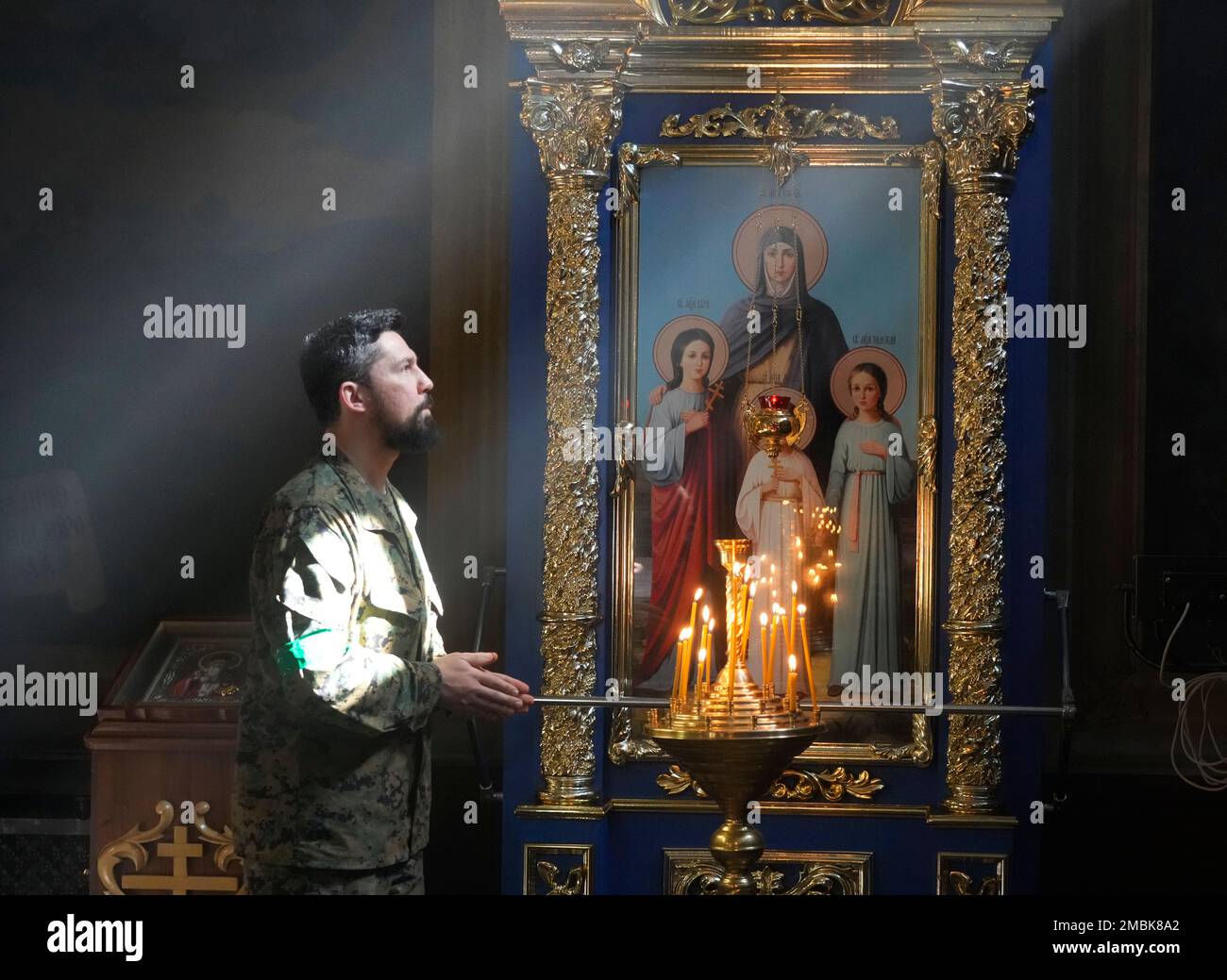 A Ukrainian soldier prays in St. Michael Cathedral during Easter ...