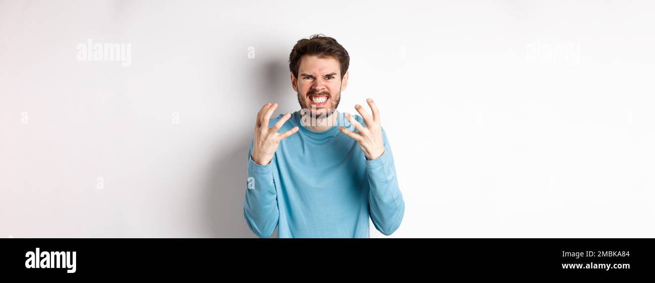 Angry caucasian man shaking hands and grimacing, looking with mad face ...