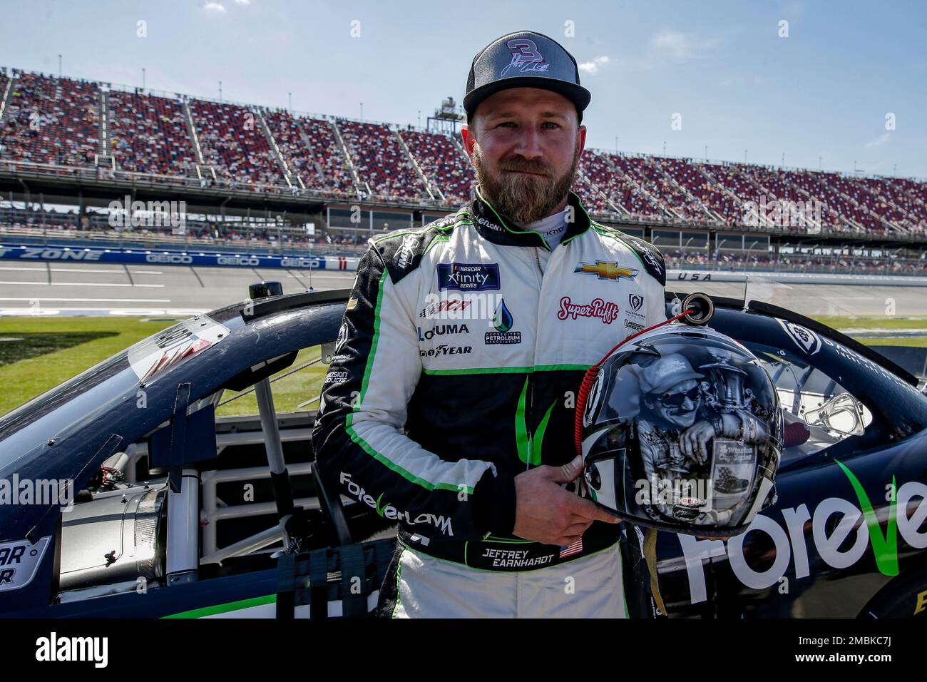 Jeffrey Earnhardt holds his helmet with a portrait of his grandfather ...
